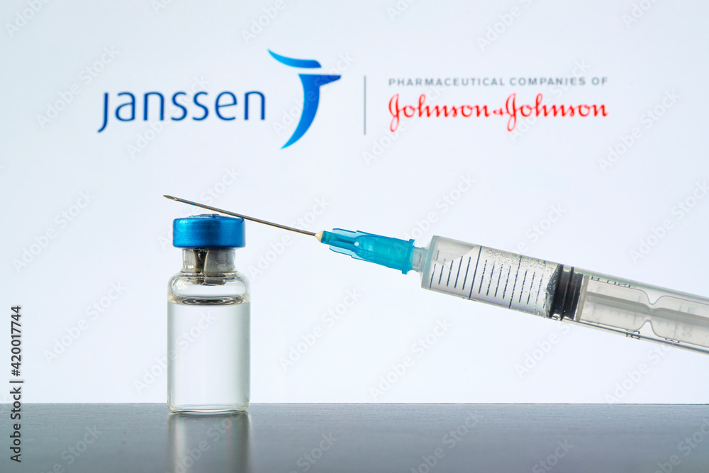A vaccination syringe and a glass ampoule with a clear liquid on a blue ...