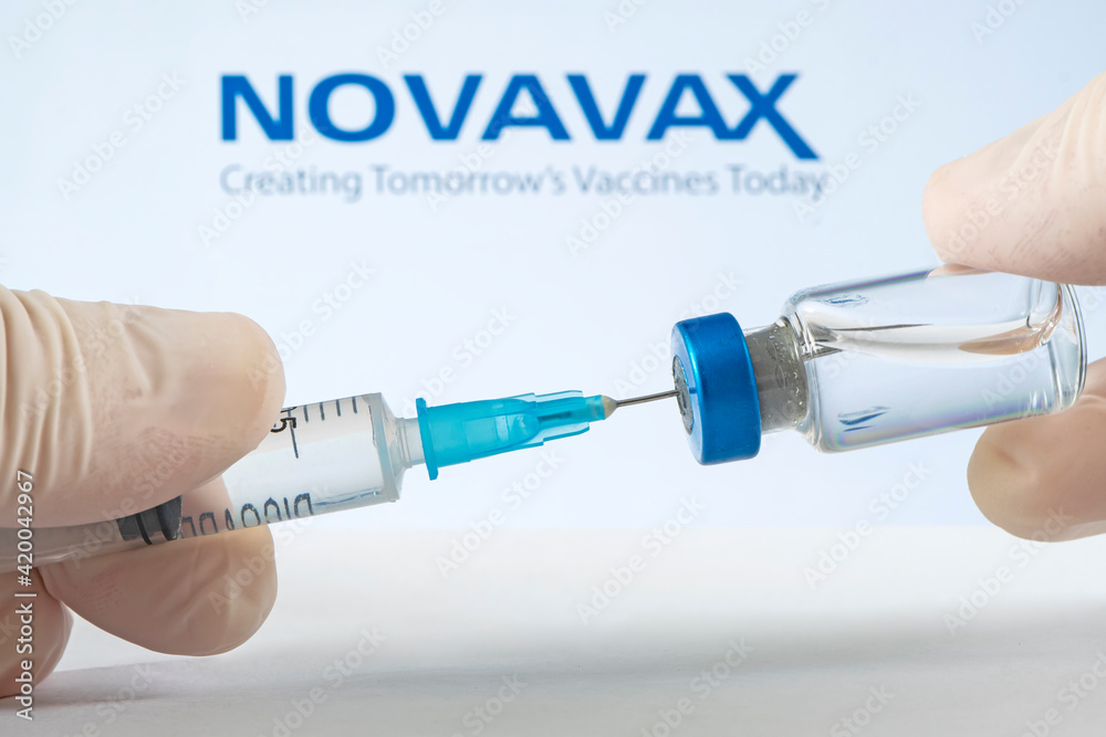 A vaccination syringe and a glass ampoule with a clear liquid on a blue ...
