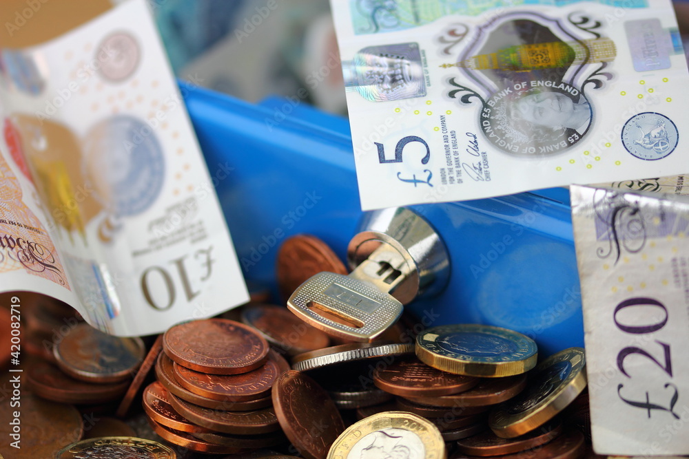 Bank notes and coins in savings box with key Stock Photo | Adobe Stock
