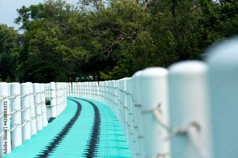 Green plastic floating corridor And there are white handrails on the ...