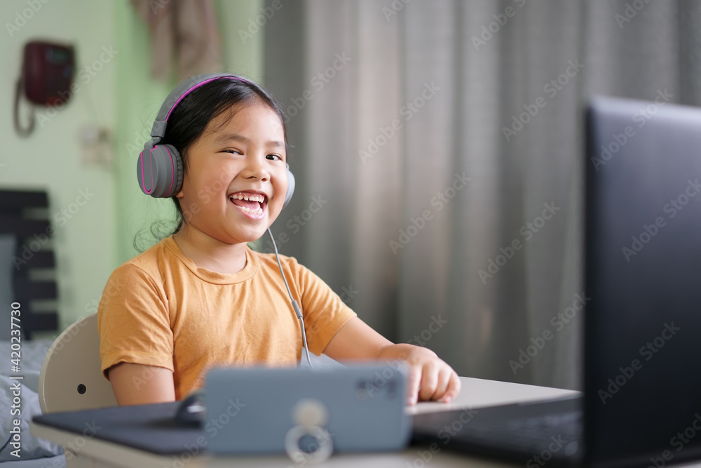 Asian child or kid girl smile e-learning on computer notebook and ...