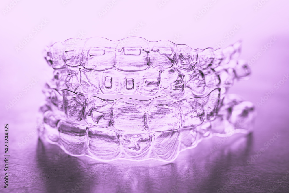 Invisible dental teeth brackets tooth aligners on pink background ...