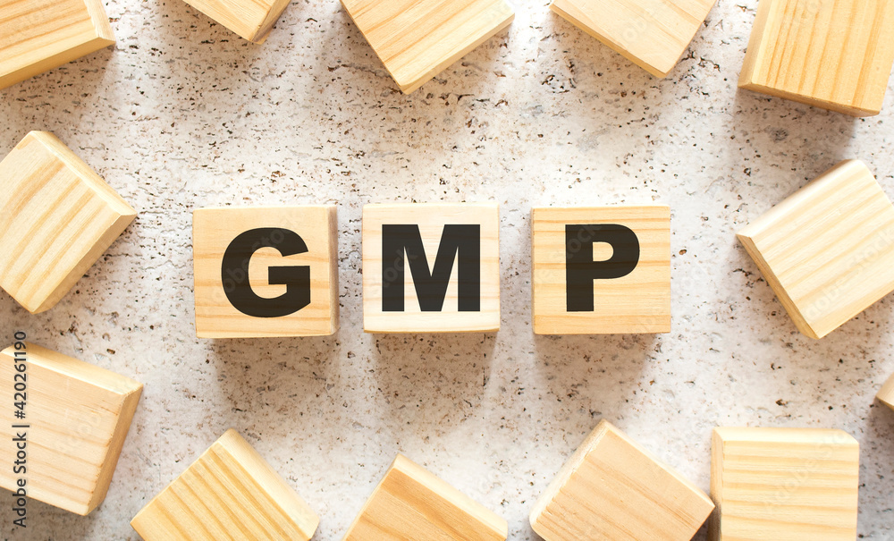 The word GMP consists of wooden cubes with letters, top view on a light background. Stock Photo ...
