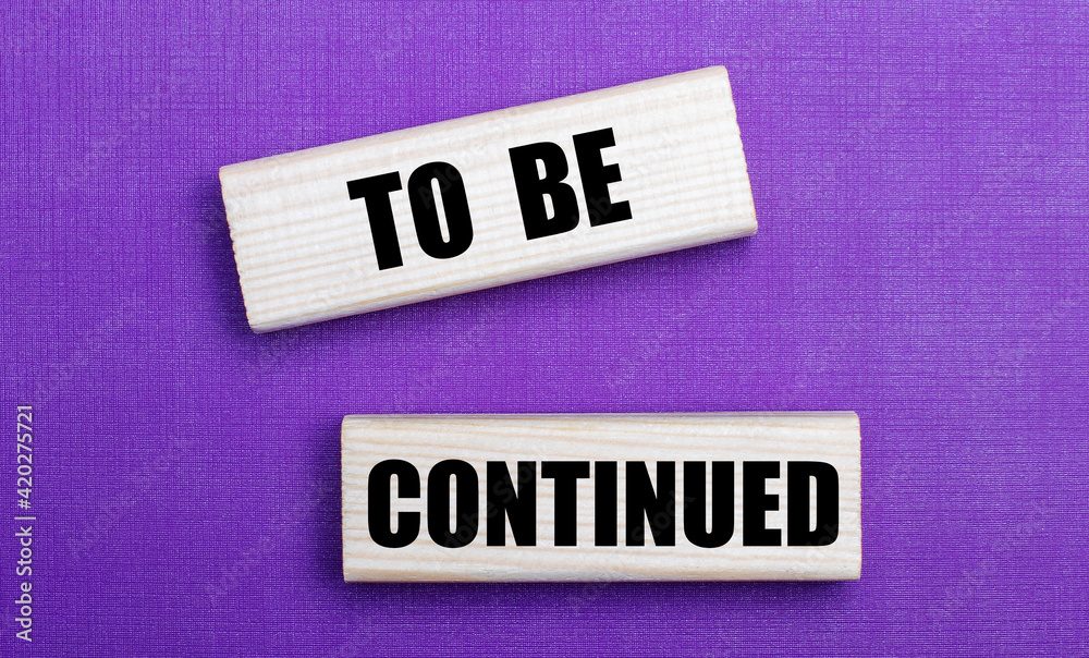 On a lilac bright background, light wooden blocks with the text TO BE ...