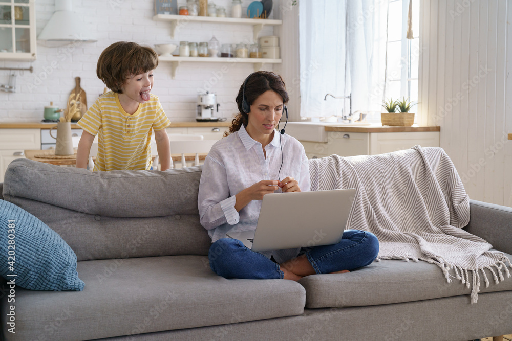 Mother freelancer talking on video call, remote working on laptop from ...