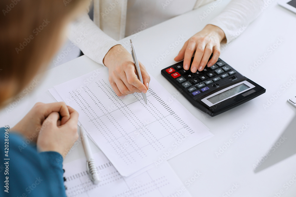 Accountant checking financial statement or counting by calculator ...