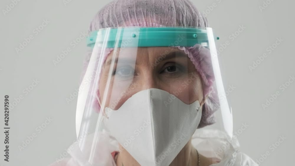 Portrait of female medical worker with face mask and shield. EMS ...