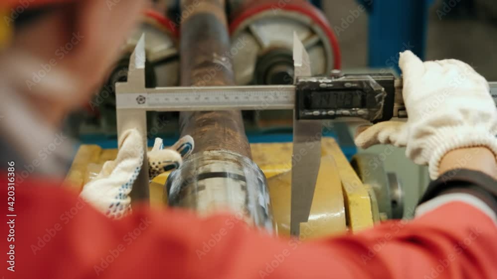 Quality control of Drill pipe production at factory. Checking accuracy ...