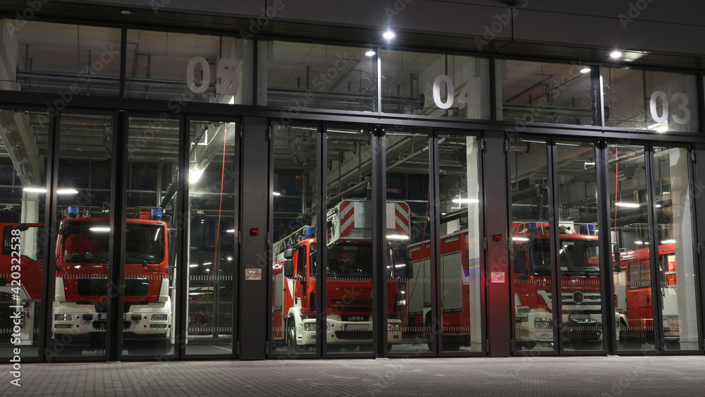Fire station view at night with fire trucks parked in front of the ...