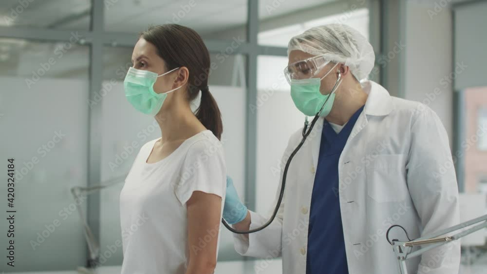 A professional pulmonologist examines a young female patient with a ...