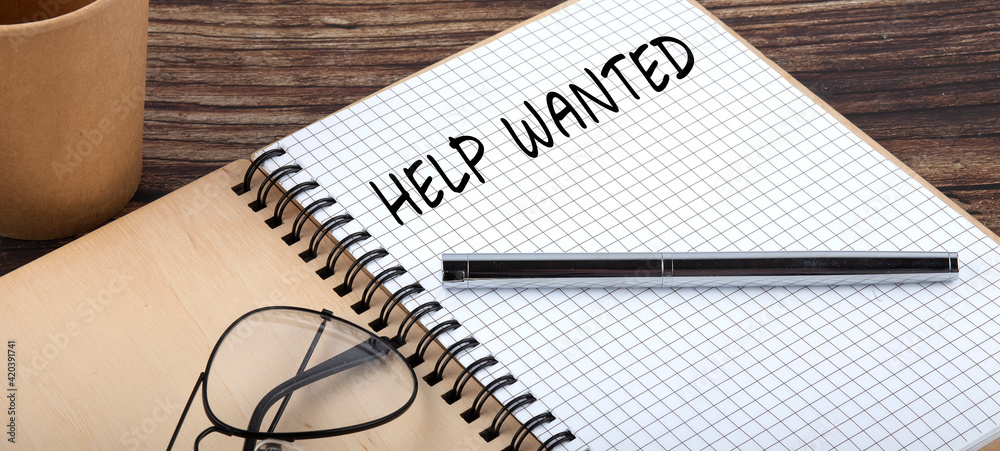 HELP WANTED words written in an office notebook. Concept in business ...