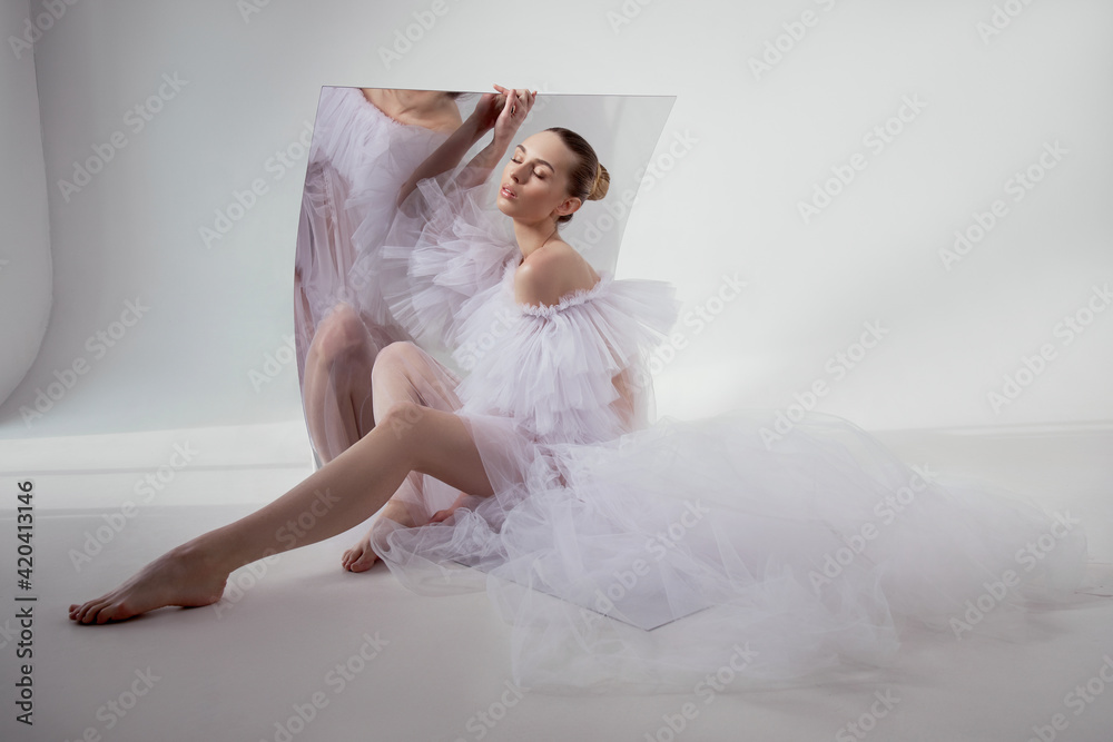 Romantic beauty woman in a light transparent dress is reflected in a ...