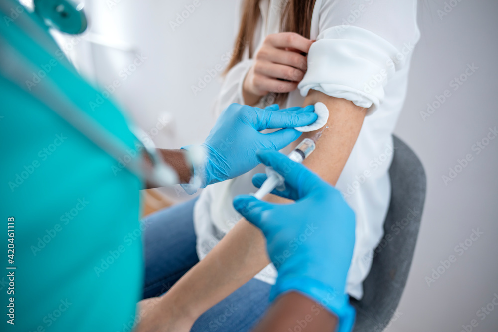 Woman is receiving a Covid-19 vaccination in doctor's office from nurse ...