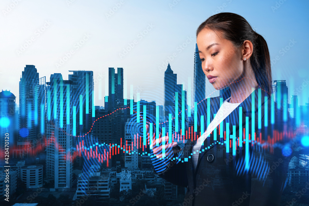 Attractive Asian businesswoman trader checking quotes to forecast the ...
