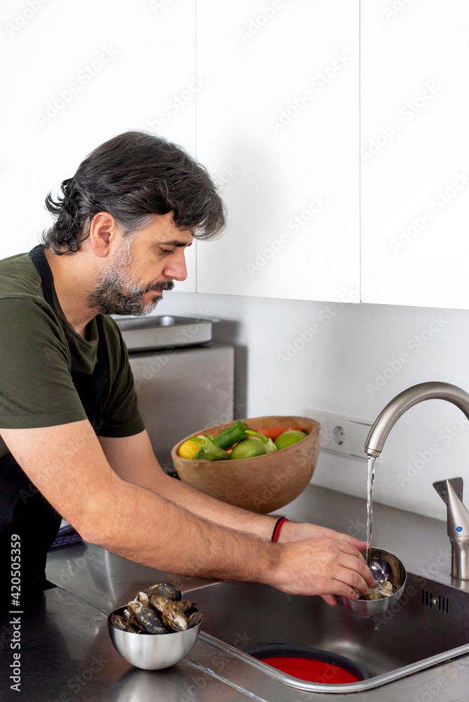 Chef washing mussels and clams in the kitchen sink Stock Photo | Adobe ...
