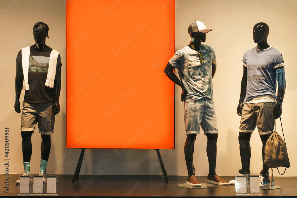 Male mannequins near a stand in a shop window. Spring summer collection ...