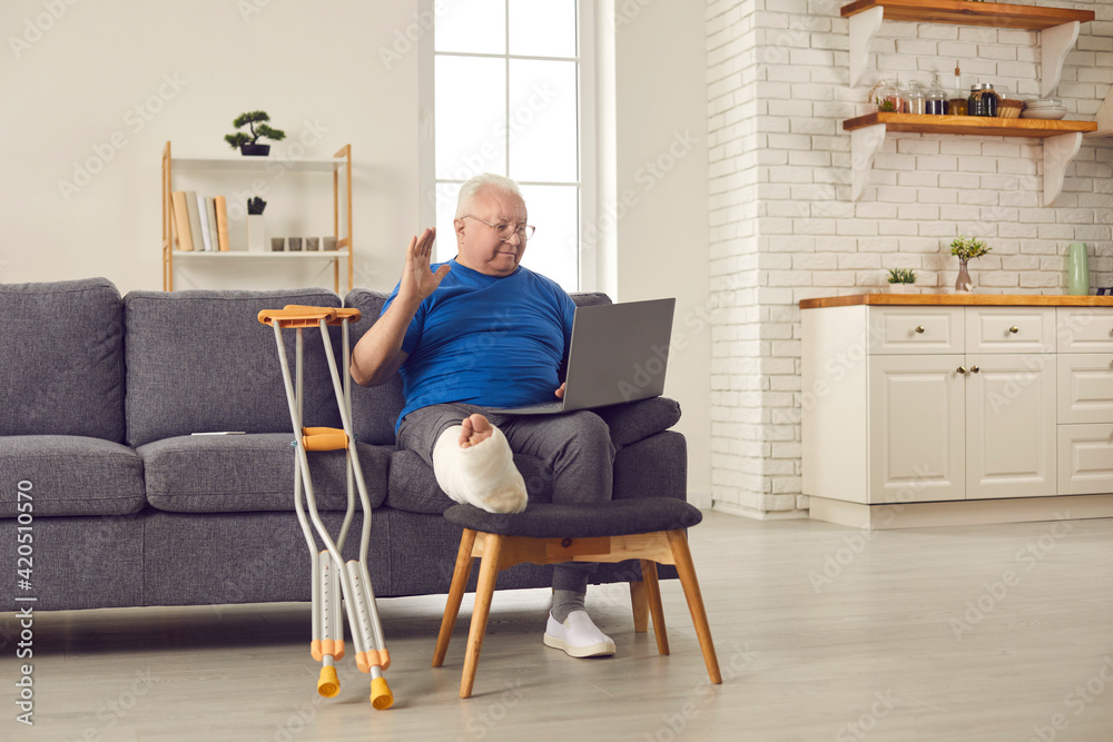 Senior patient with physical injury having video call with family or ...