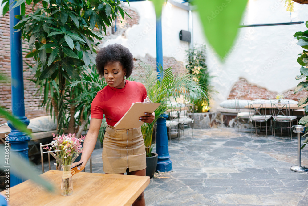 Restaurant manager adjusting table arrangements Stock Photo | Adobe Stock