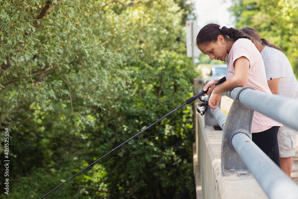 Portrait of a teen girl peering over a ledge as she and her grandfather ...