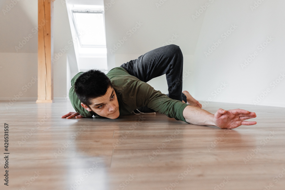 Flexible guy pressing against floor during dance Stock Photo | Adobe Stock