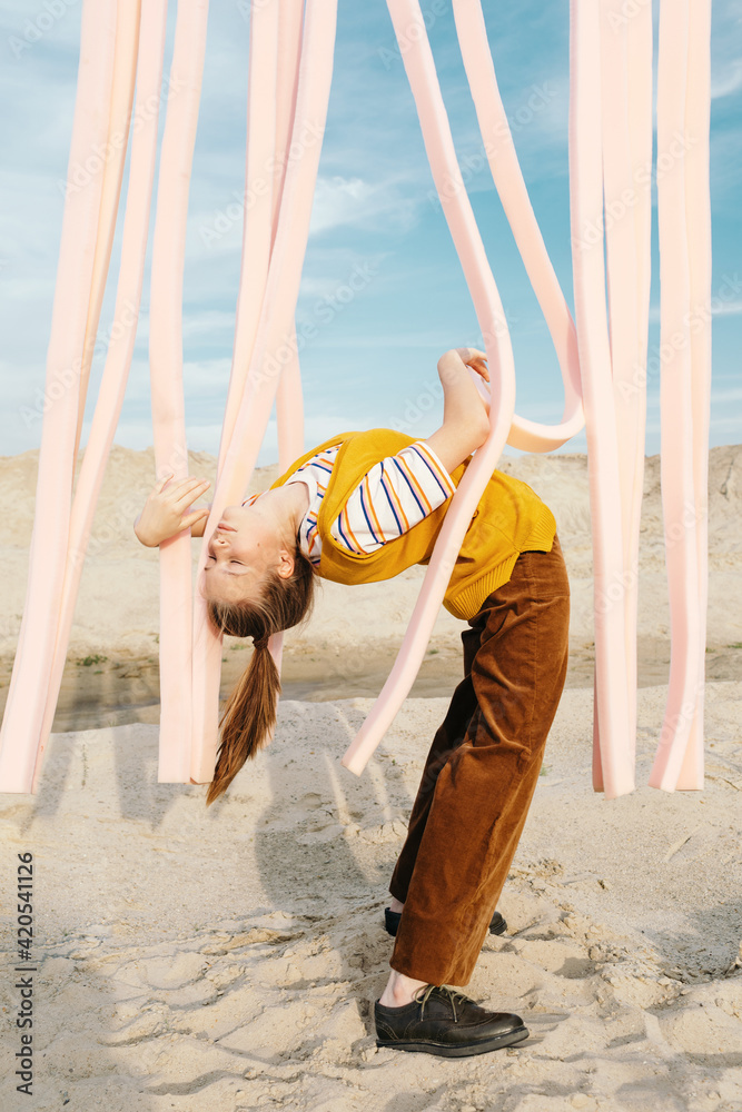 Teen female model in trendy outfit posing on sand Stock Photo | Adobe Stock