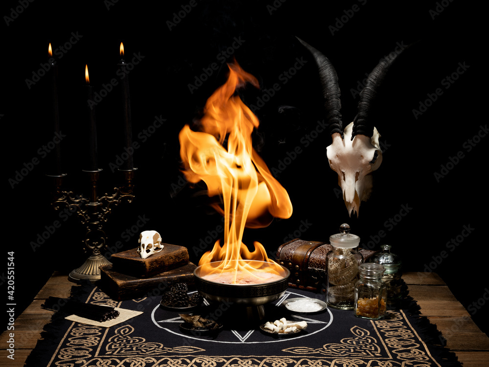 Satanic black magic ritual with fire. Animal skulls and candles ...