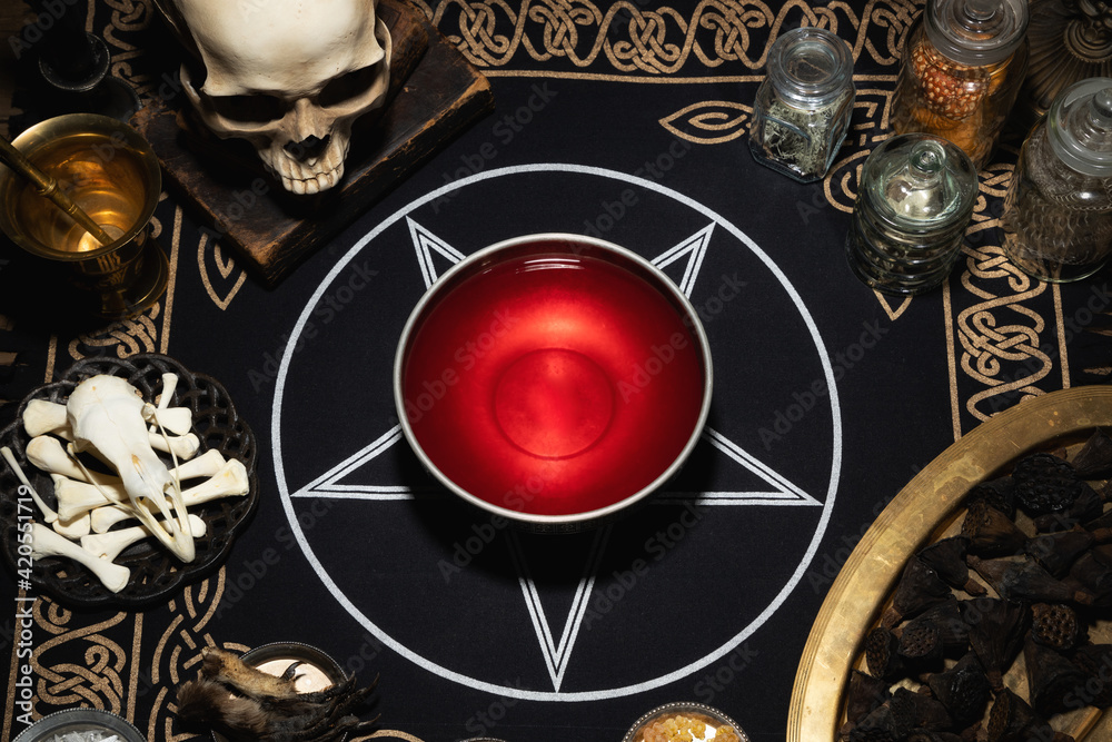 Ritual bowl with blood on the table. Mystic background with occult and ...