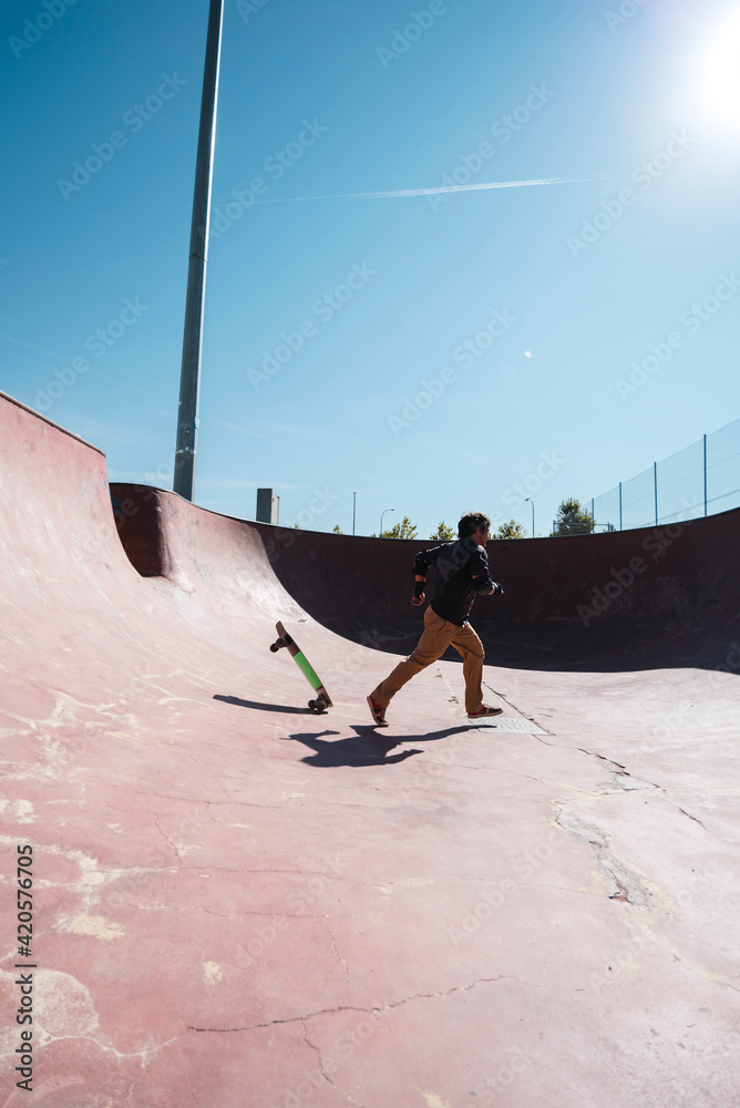 Mid aged man skateboarder in his forties failing stunt on ramp at skate ...