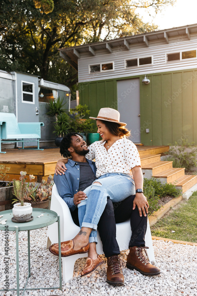 Cute stylish couple sitting outdoors, enjoining the late afternoon ...