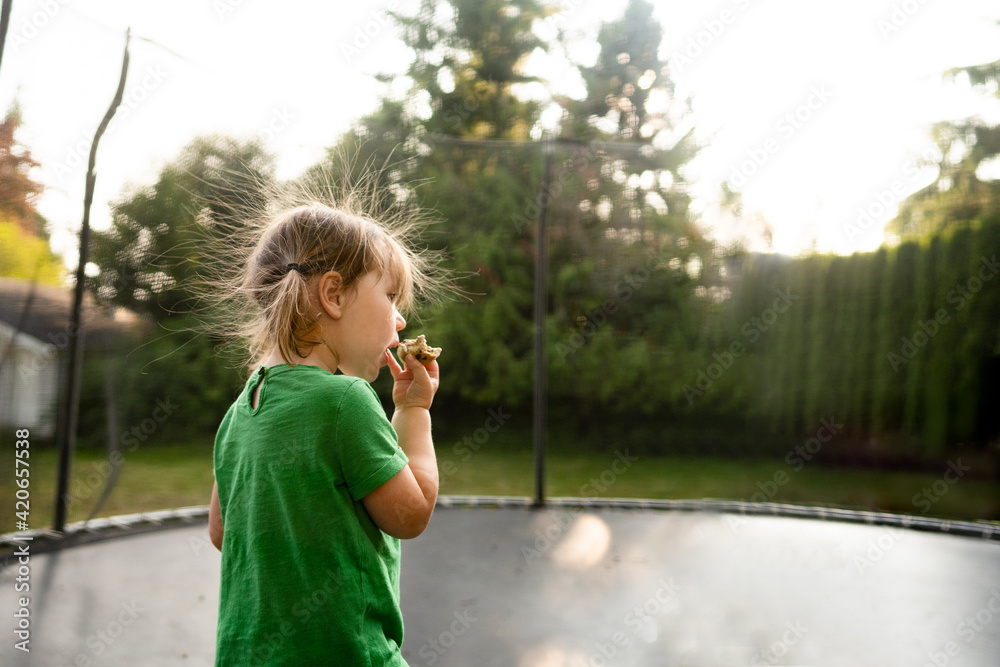 Girl with hair sticking up from static eats on trampoline Stock Photo ...