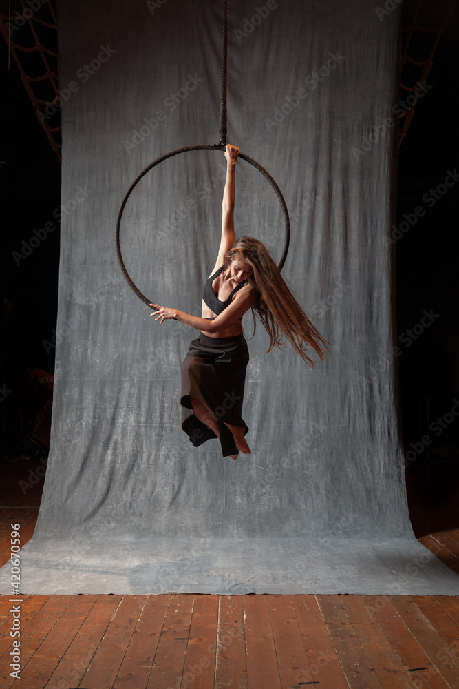 elegant pose of a circus aerialist on a Lyra or Aerial hoop Stock Photo ...