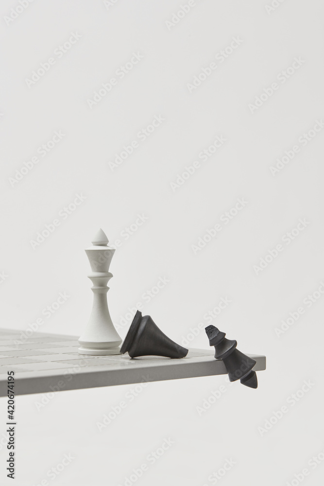 Defeated and broken black chess king by a white king. Stock Photo ...