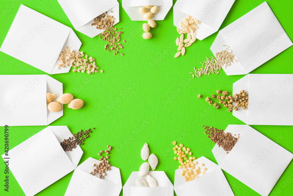 Circle shape created from many white packs of different seeds on bright ...