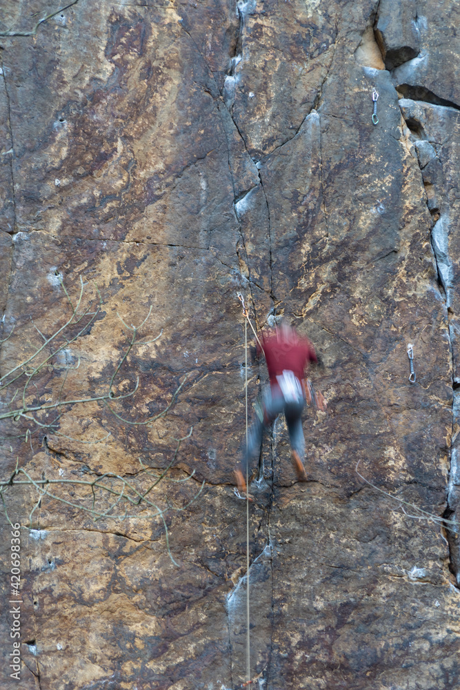 Motion blur image of a rock-climber with a safety rope falling down ...