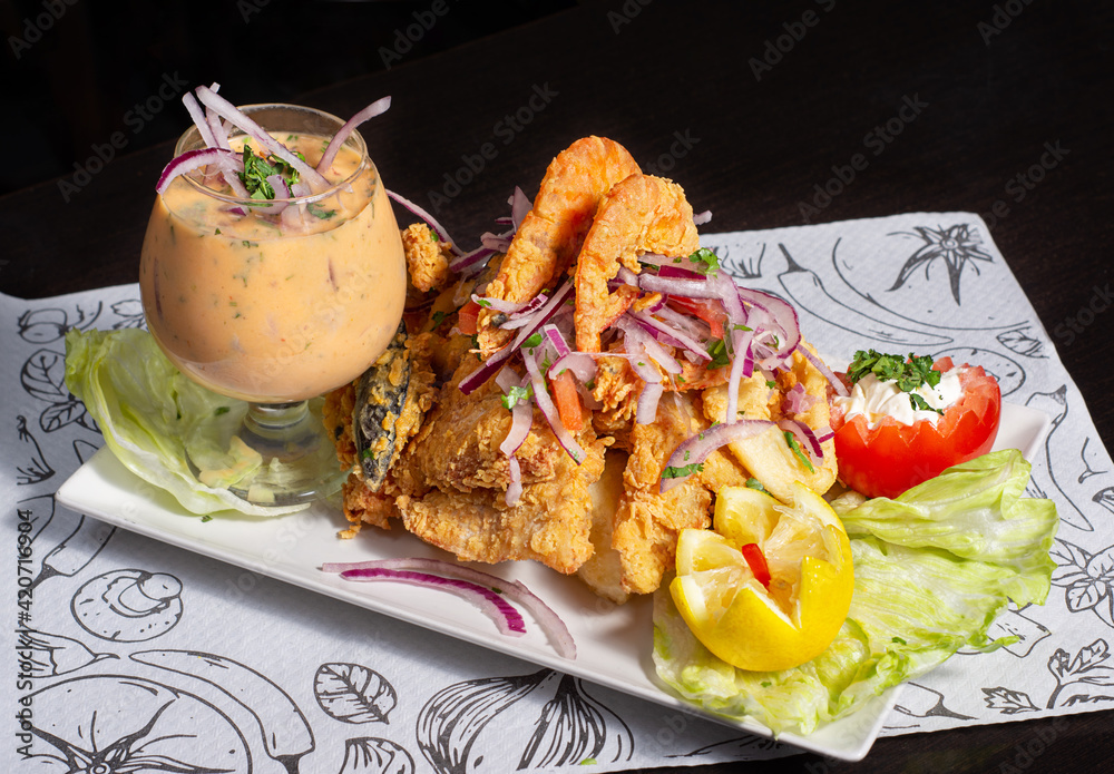 Peruvian traditional food. Fried fish with shrimp, onion, lemon ...