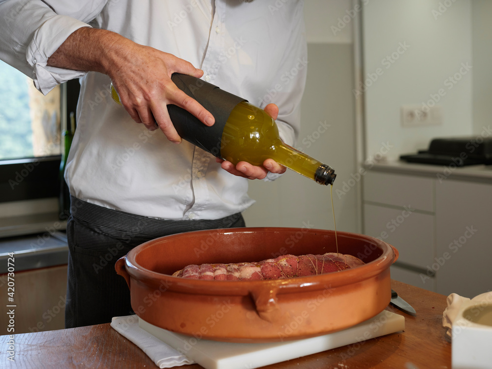 Man pouring oil on meat Stock Photo | Adobe Stock