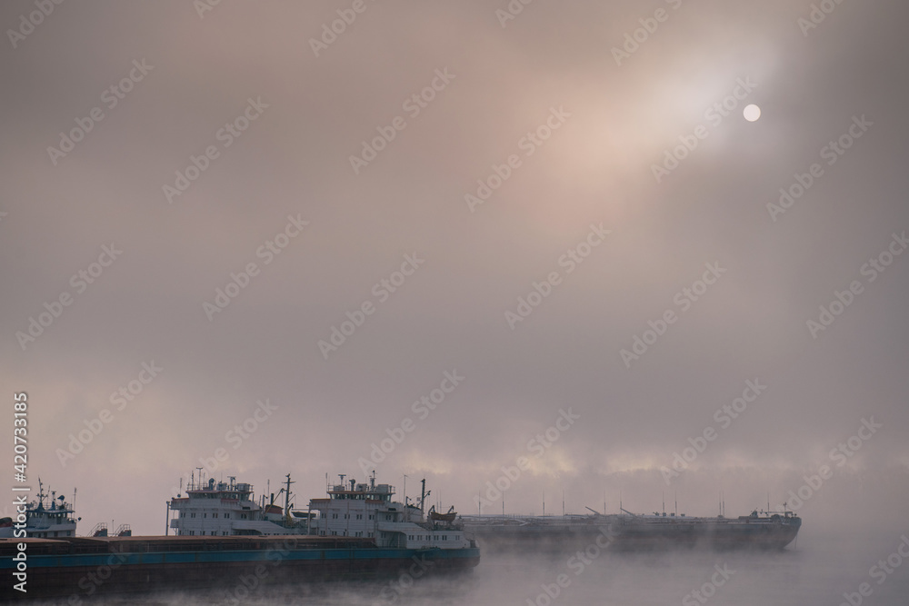 Empty cargo ships covered with fog in the shipyard Stock Photo | Adobe ...