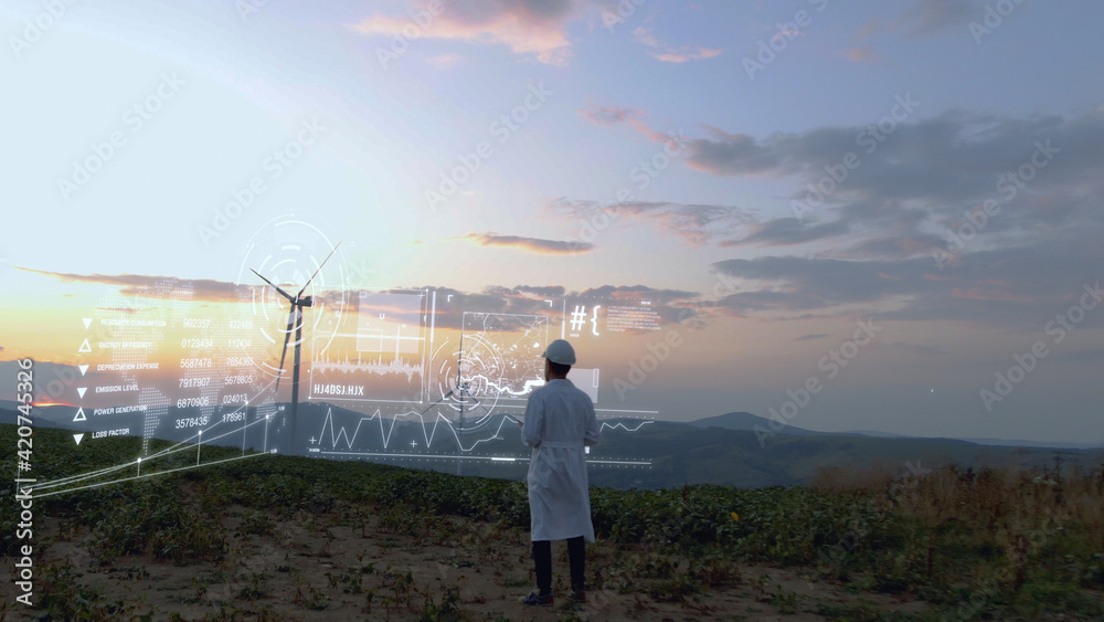 Adult man in white uniform working on wind farm on sunset using ...