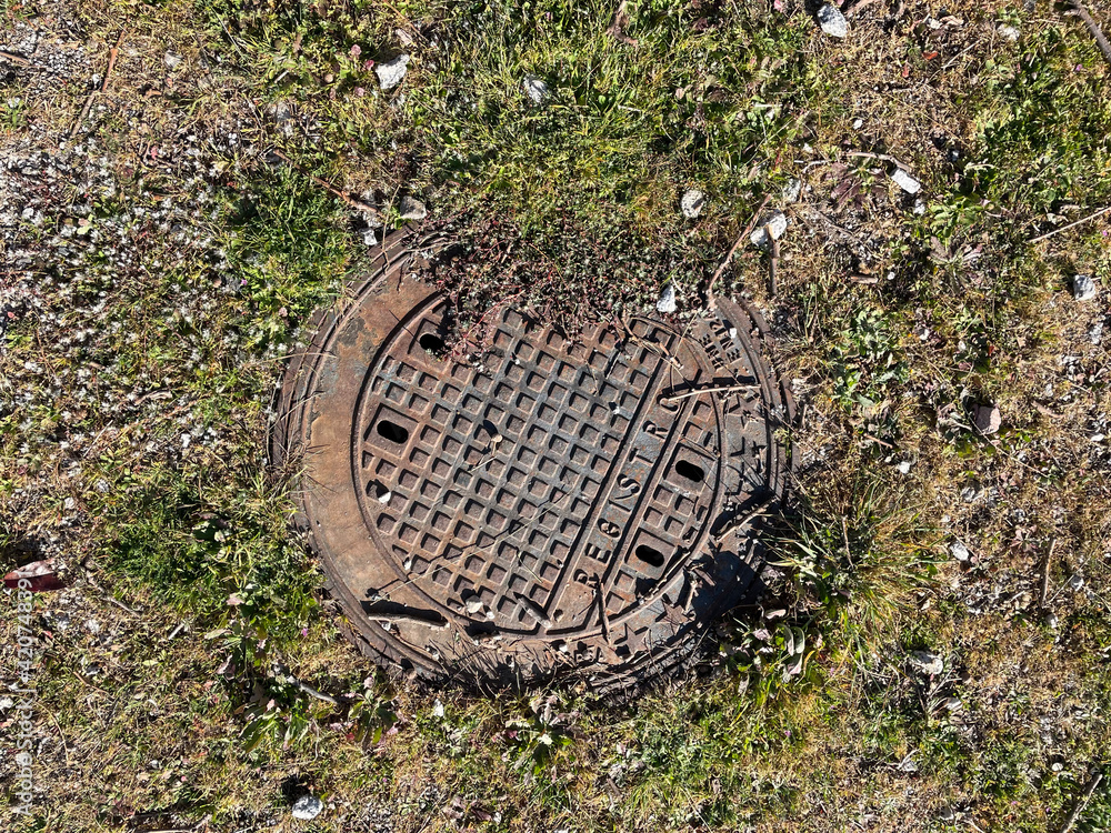 Foto de Manhole on natural ground with rust stains do Stock | Adobe Stock