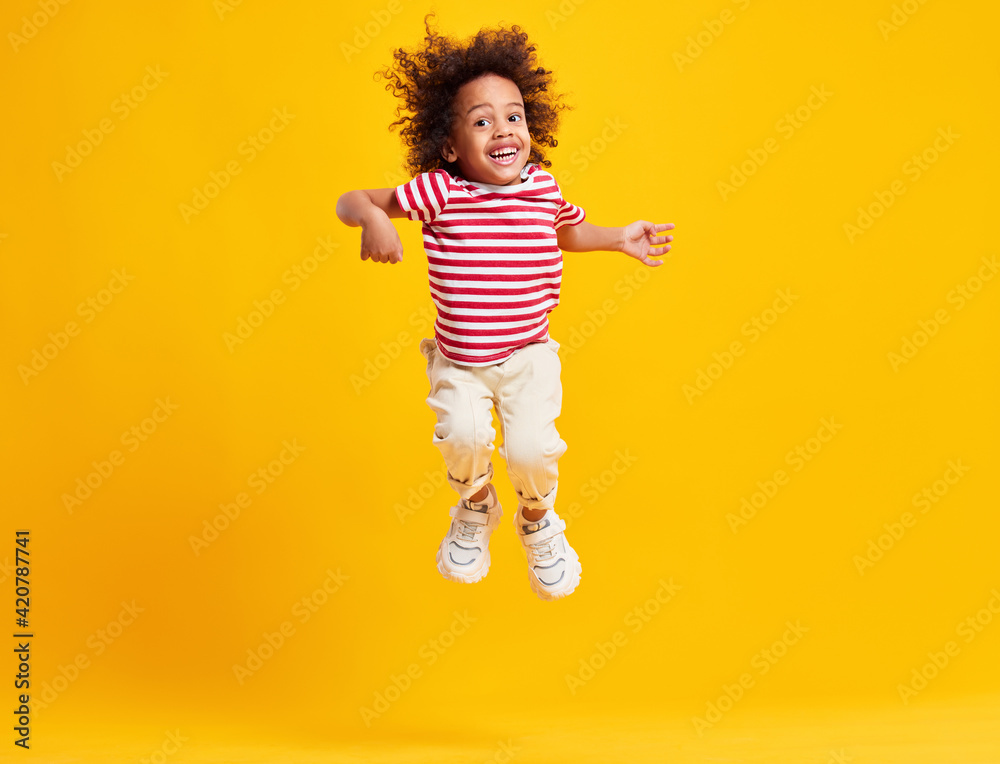 Active positive black kid jumping against blue background Stock Photo ...
