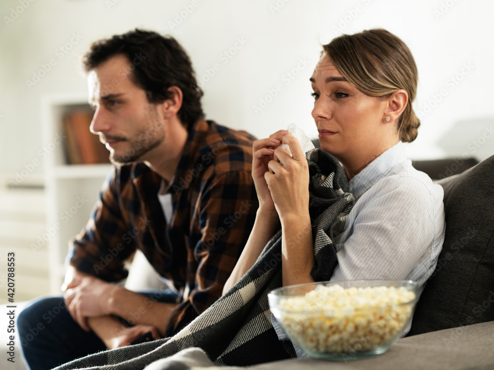 Young loving couple watching sad movie together. Young woman crying ...