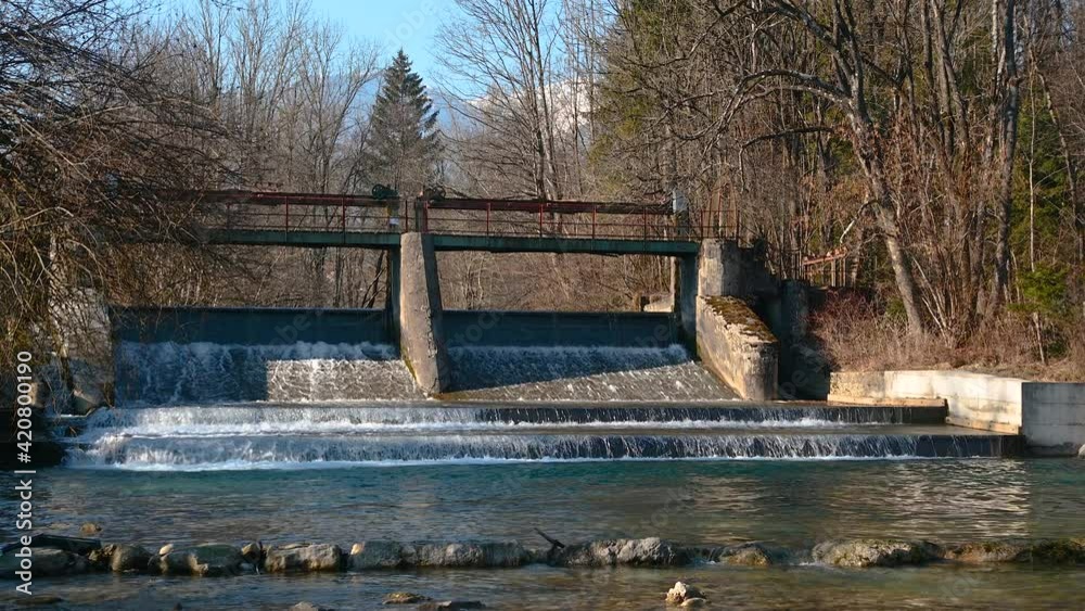 Concrete old spillway in forest with flowing water. Abandoned river dam ...