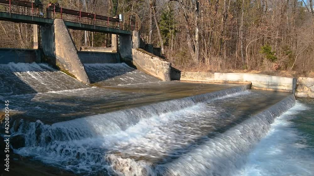 Concrete old spillway in forest with flowing water. Abandoned river dam ...