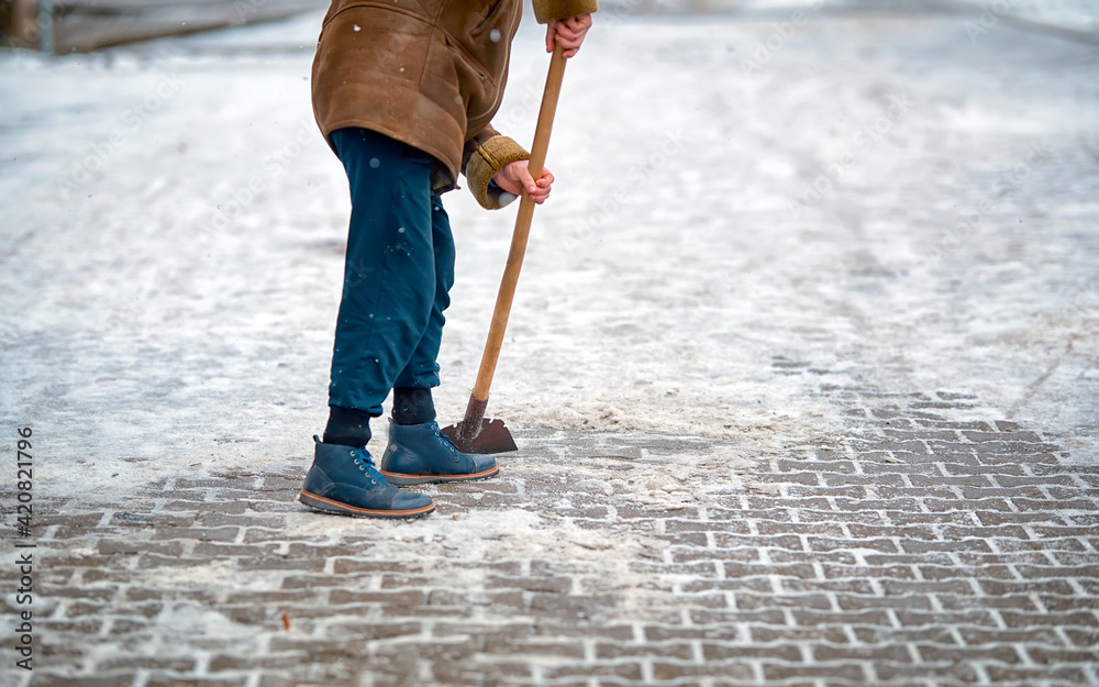 Worker clean ice and remove snow with icebreaker tool from paving slabs ...