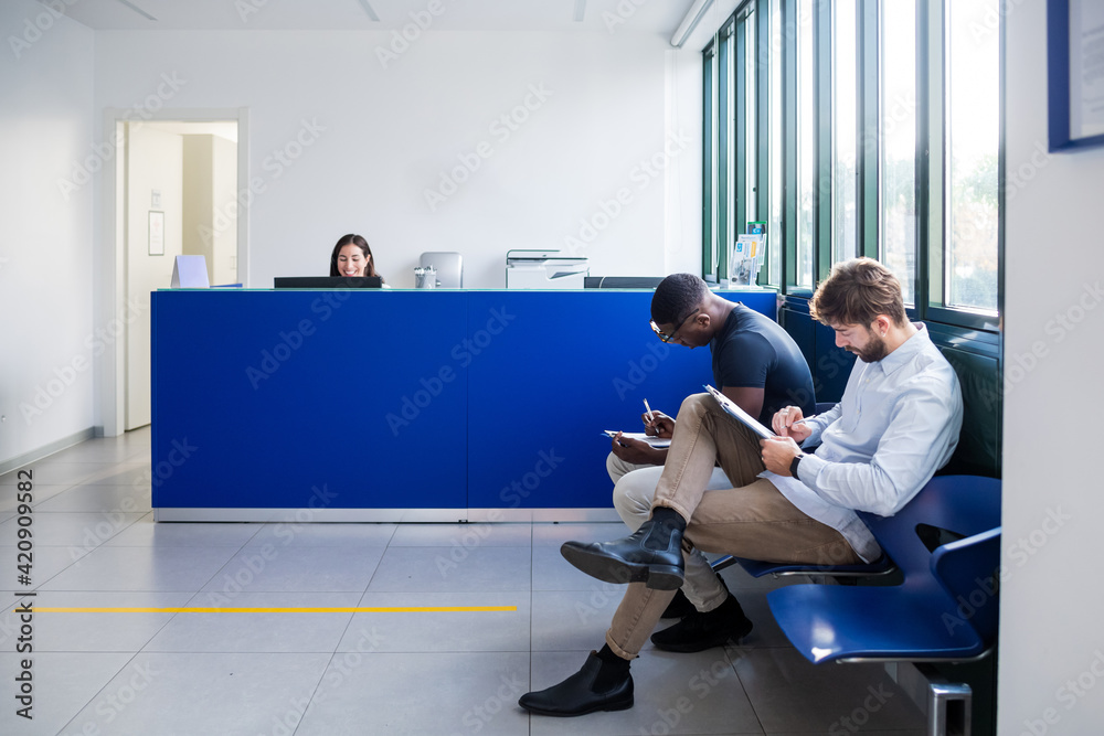 Patients completing forms at hospital reception Stock Photo | Adobe Stock