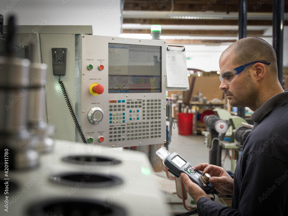 Knife factory worker operating machinery controls Stock Photo | Adobe Stock