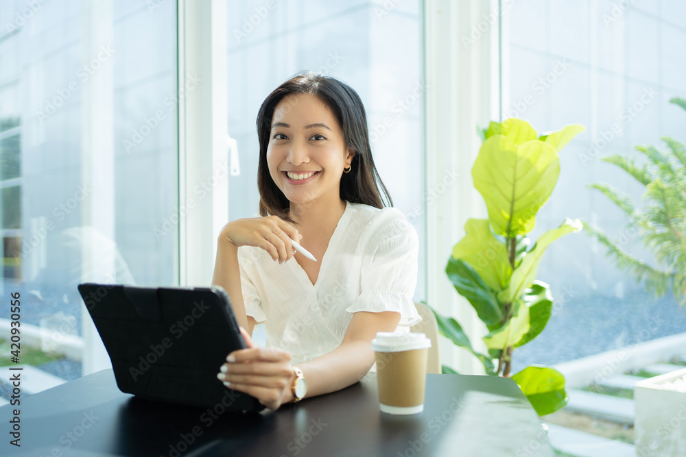 Asian business woman Using the tablet She is having a video ...