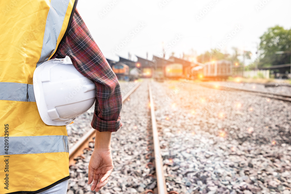 Back view of train engineering standing and holding hardhat at work ...