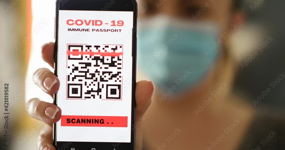 Person holds a mobile phone to scan the QR code COVID-19. Digital ...