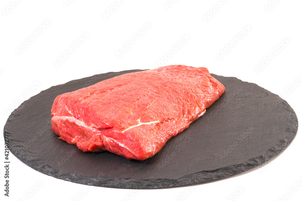 Fresh beef on a dark round surface on a white background. The shoulder ...